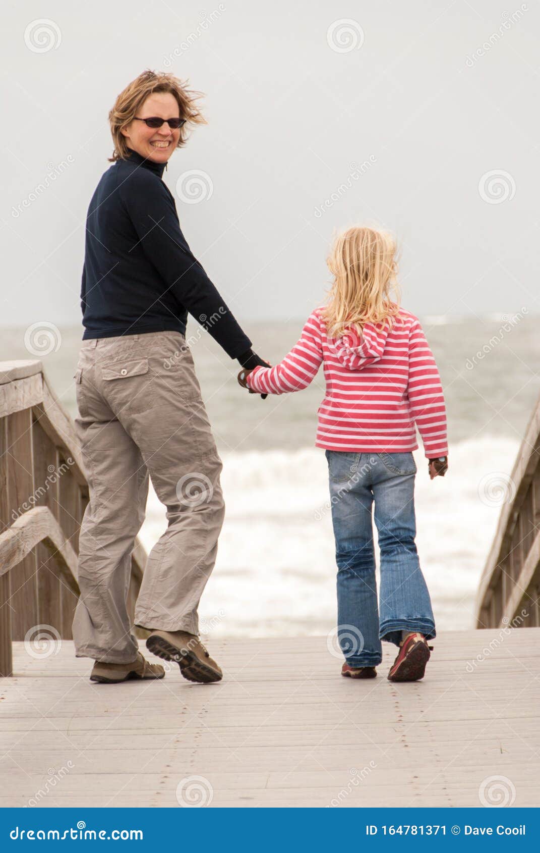 Mor Och Unga Dotter Går Längs Med En Promenad Mot Ett Stormigt Hav