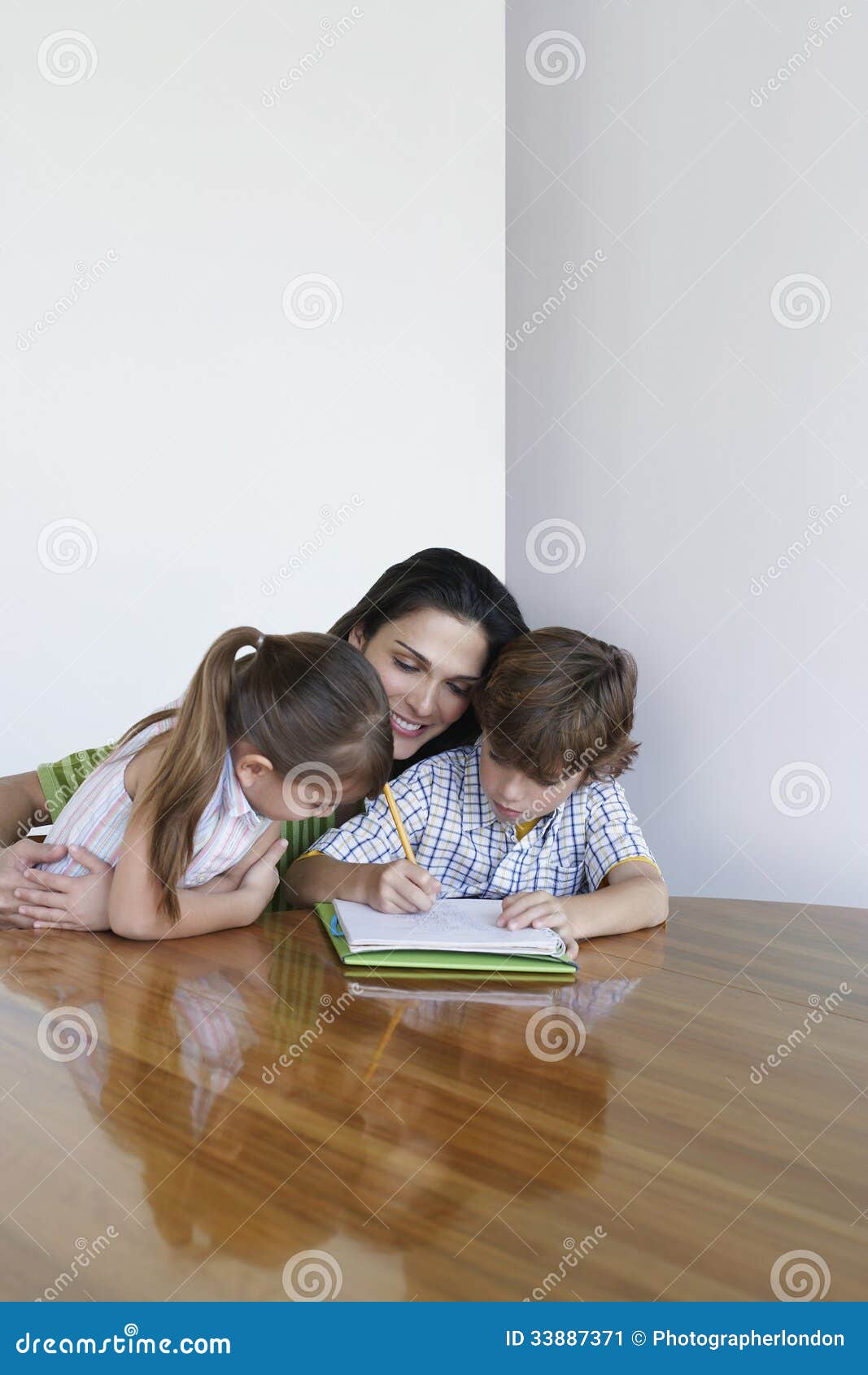 Mother Assisting Children in Homework at Table Stock Image - Image of ...