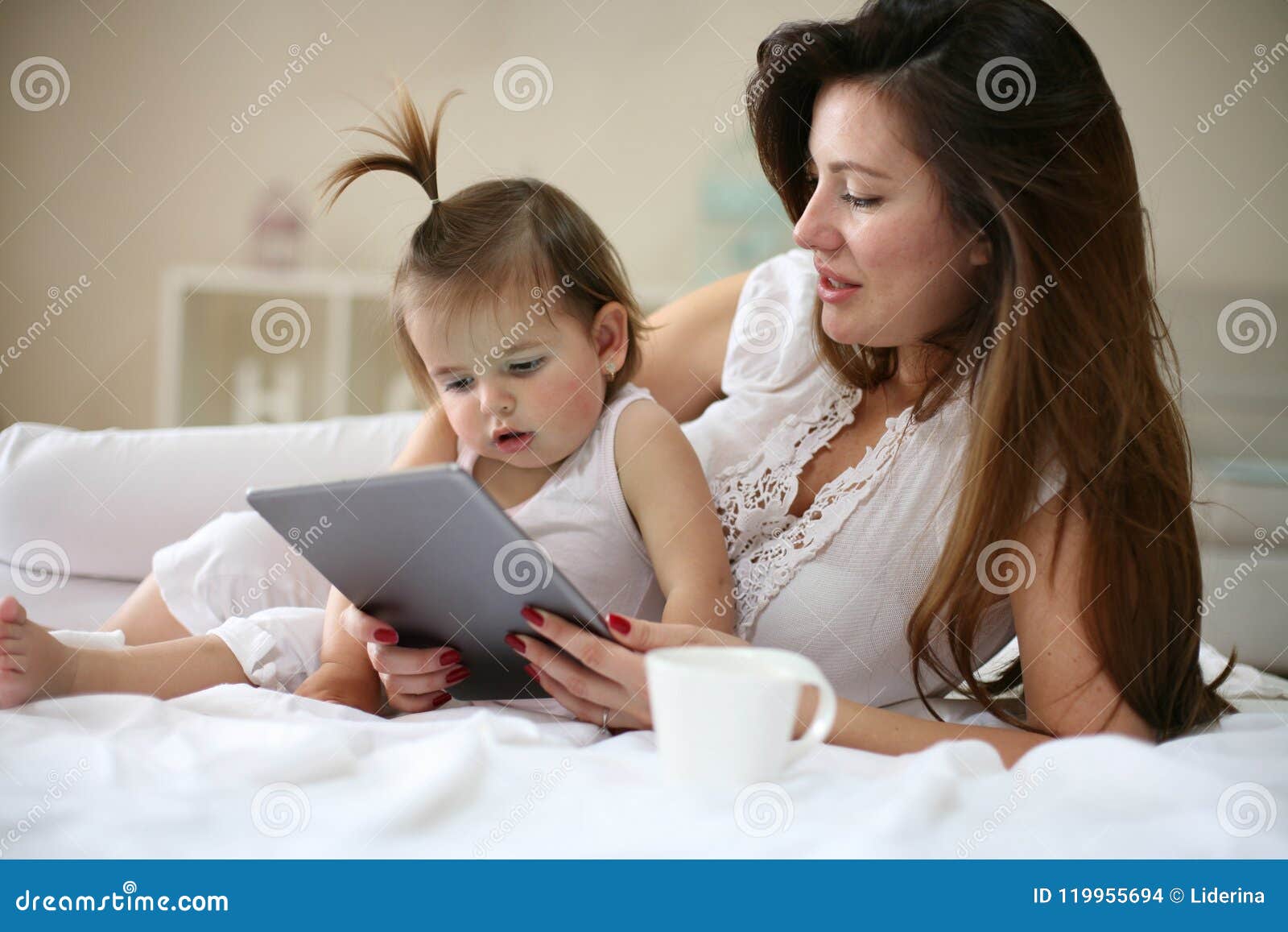 Mother and Baby on Bed. Mother and Baby Using Digital Tablet Stock ...