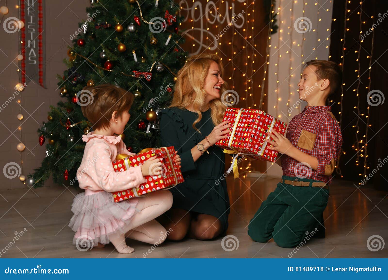 Mother and Children Exchanging and Opening Christmas Presents. Stock ...