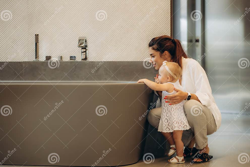 Mother And Daughter Choose A Bathtub In A Sanitary Ware Store Stock