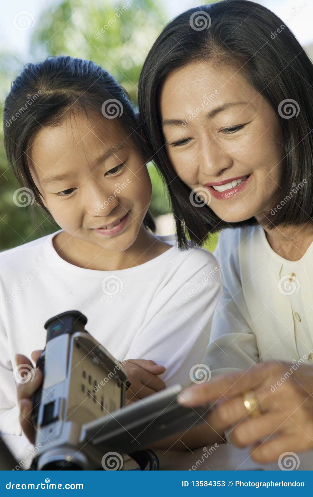Mother and Daughter Looking at Video Camera Screen Stock Image - Image ...