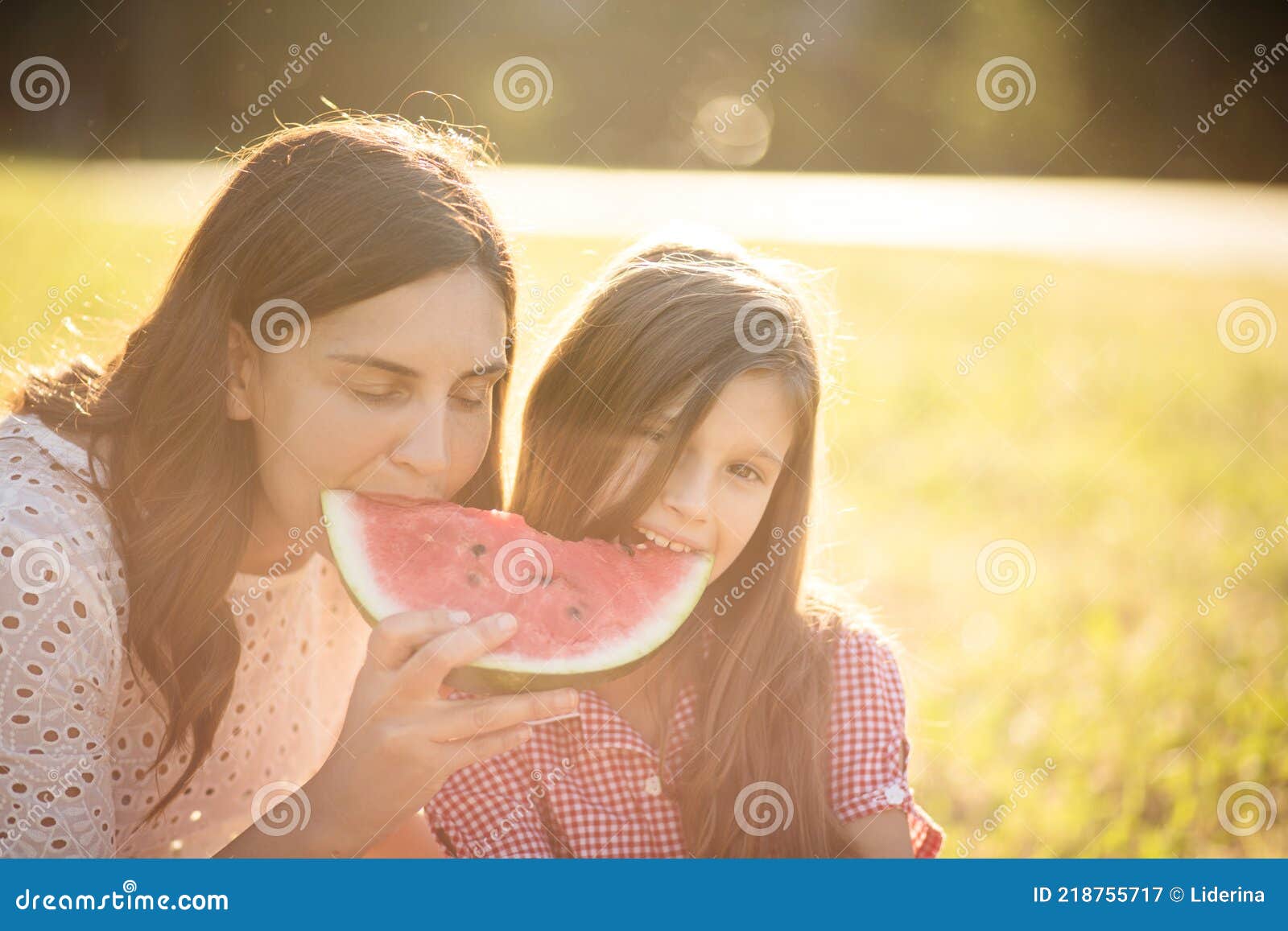Mother And Daughter Sitting In Nature And Eating Watermelon Stock Image