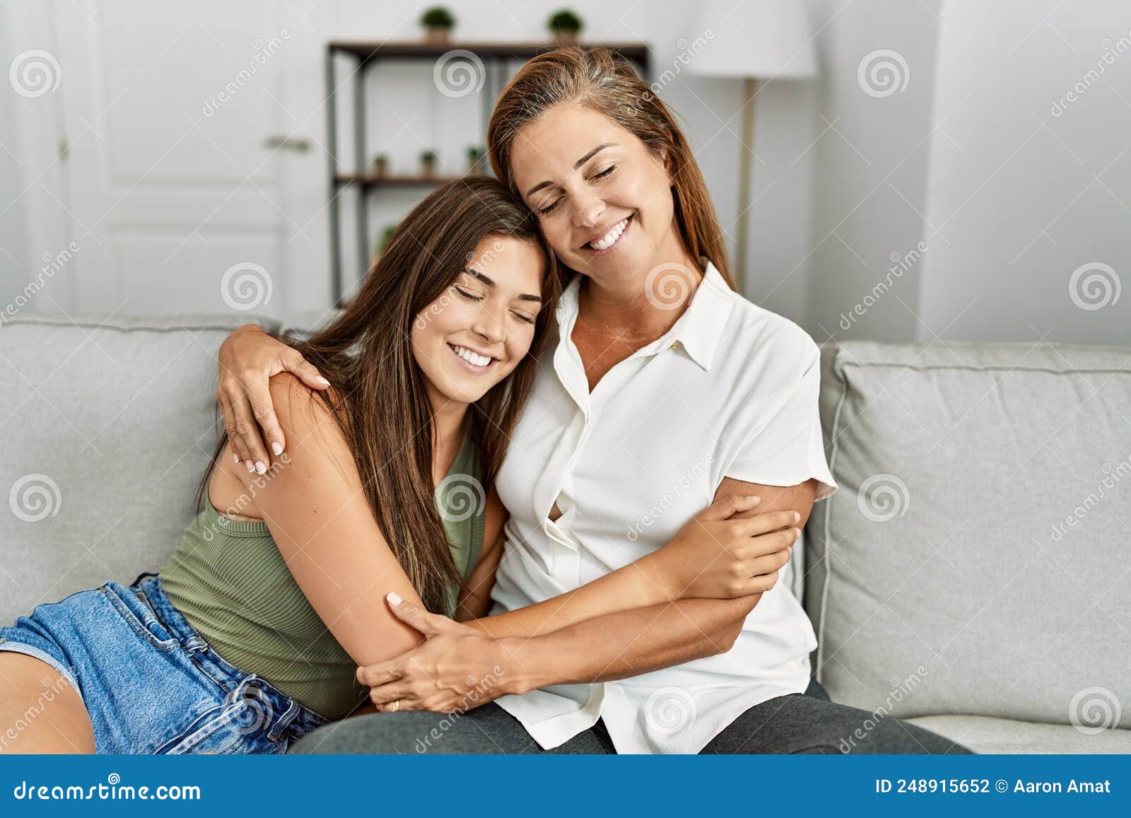Mother And Daughter Smiling Confident And Hugging Each Other Sitting On
