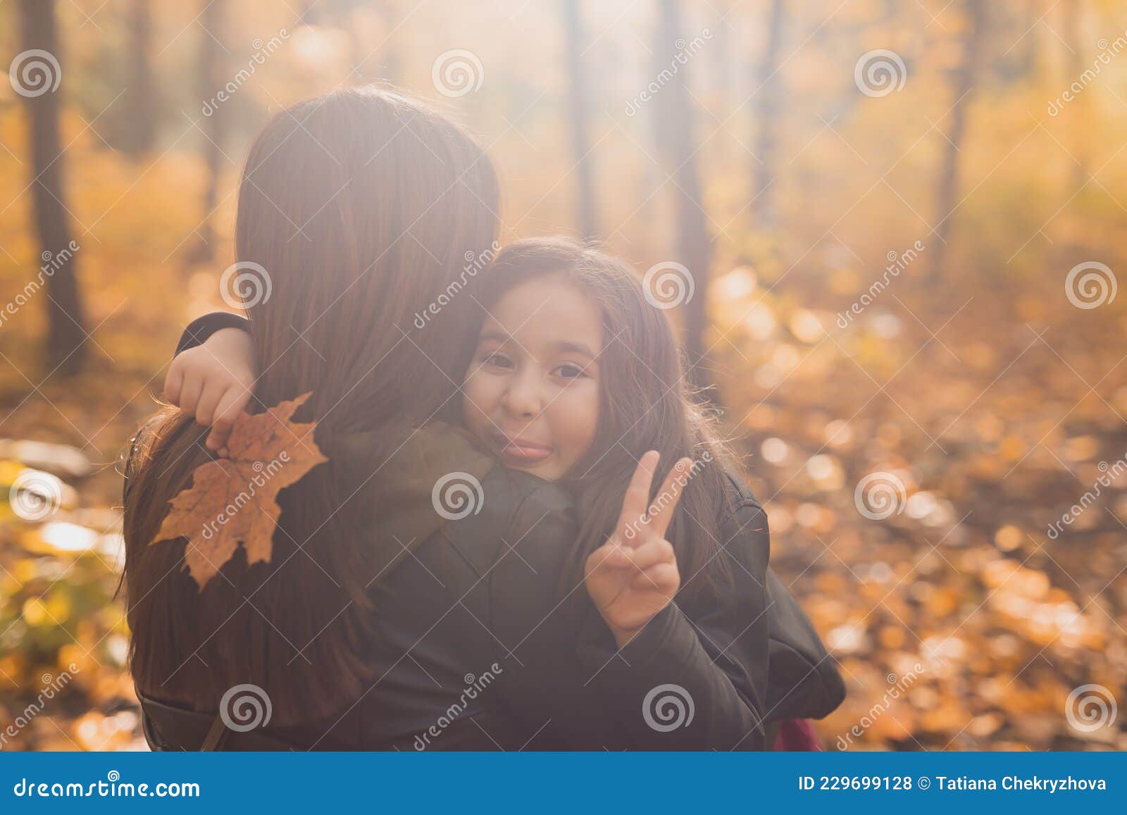 Mother And Daughter Spend Time Together In Autumn Yellow Park Season