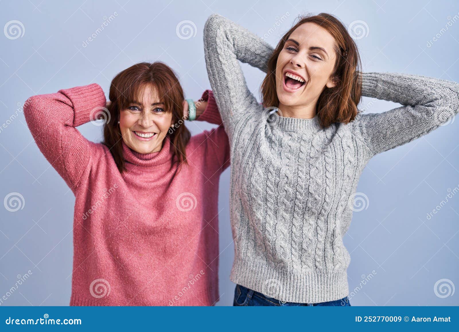 Mother And Daughter Standing Over Blue Background Relaxing And
