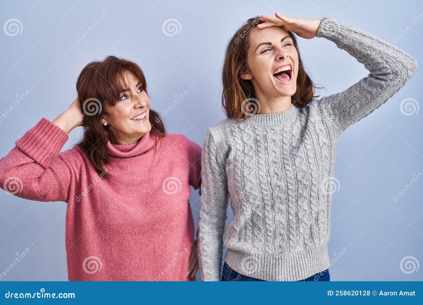 Mother And Daughter Standing Over Blue Background Smiling Confident