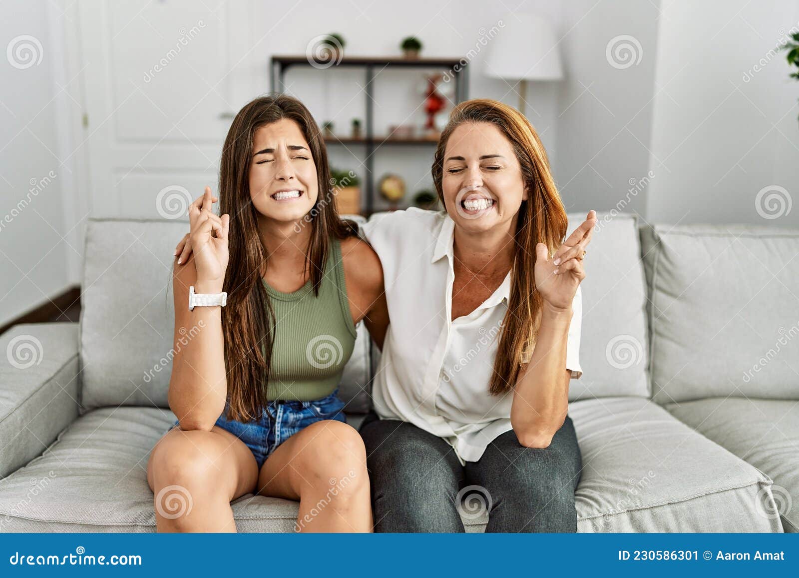 Mother And Daughter Together Sitting On The Sofa At Home Gesturing