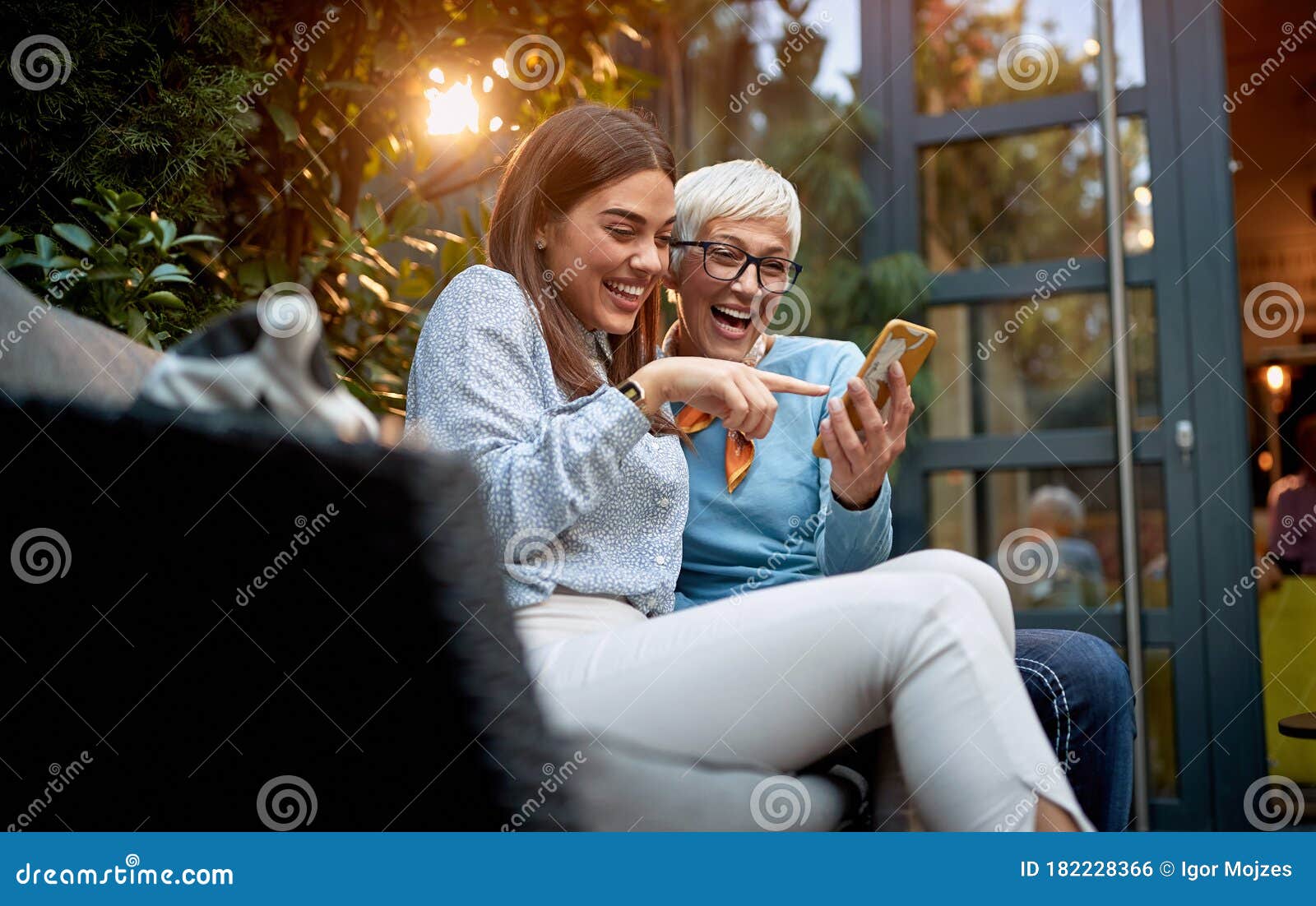 Mother and Daughter Watching Cell Phone, Smiling and Laughing Stock ...