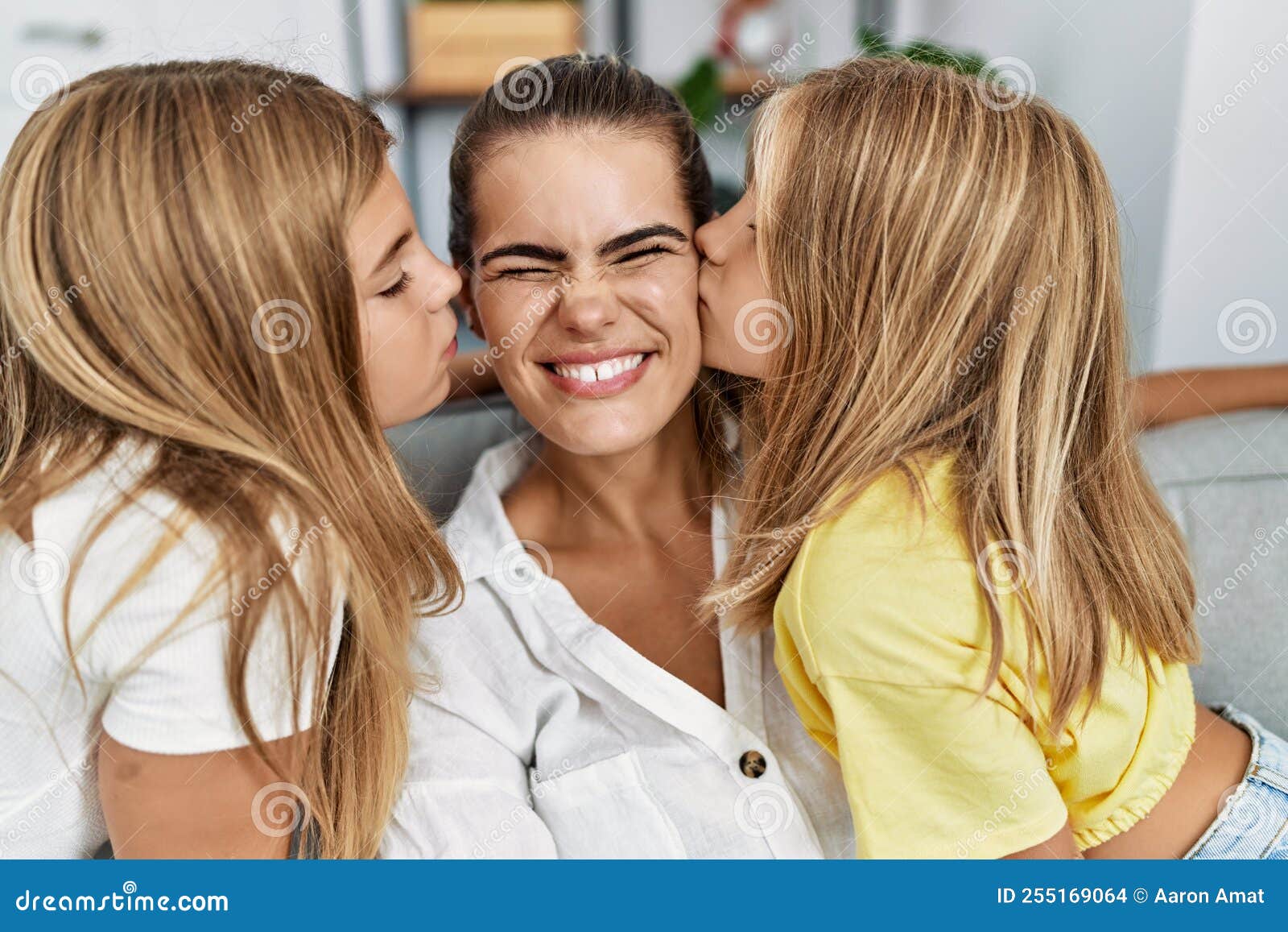 Two Daughters Kissing Mother On Isolated Red Background Girls Hugging