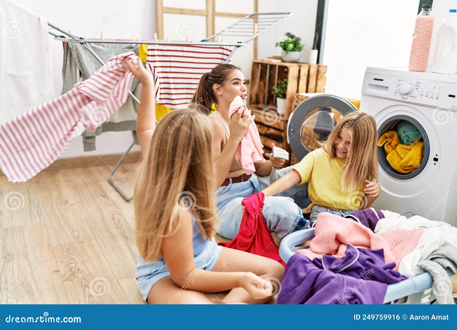 Mother and Daughters Smiling Confident Fighting with Clothes at Laundry ...