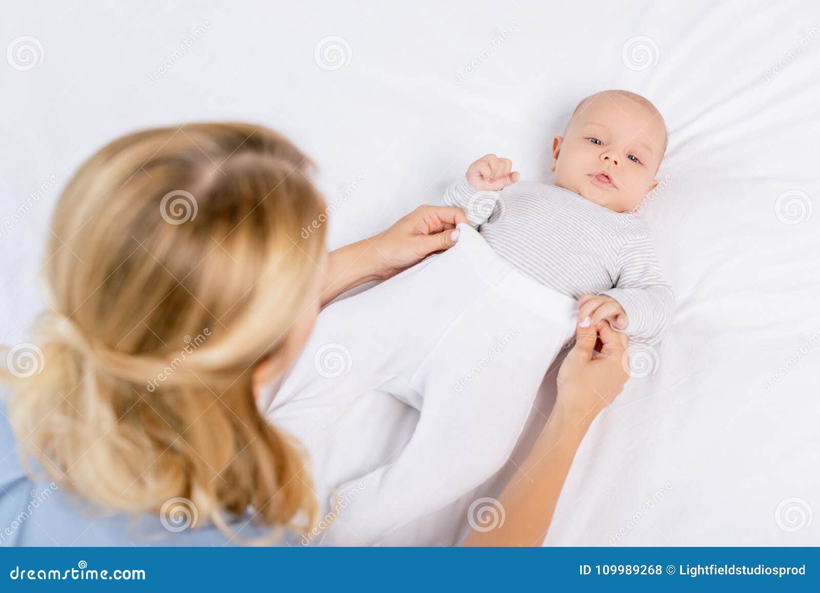 Mother dressing baby stock photo. Image of together - 109989268