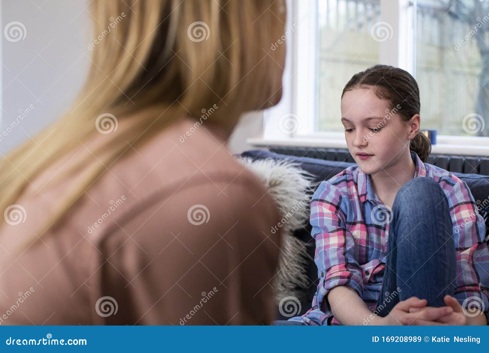 Mother Having Serious Conversation With Worried Young Daughter At Home