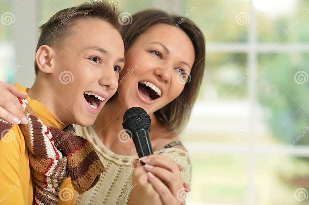 Mother and His Son Singing into the Microphone. Stock Image - Image of ...