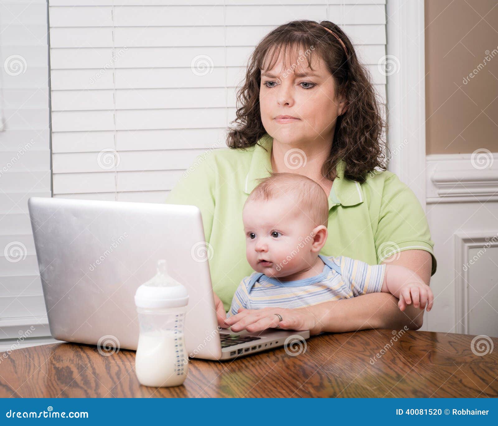 Mother Holding Baby while Working on Computer Stock Photo - Image of ...