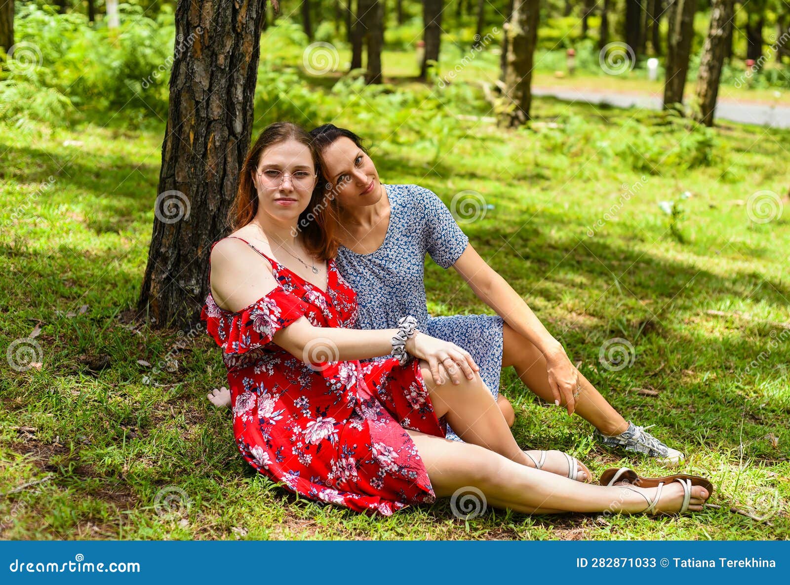 Mother Hugging Her Teenage Daughter With Dyed Hair And Glasses Against
