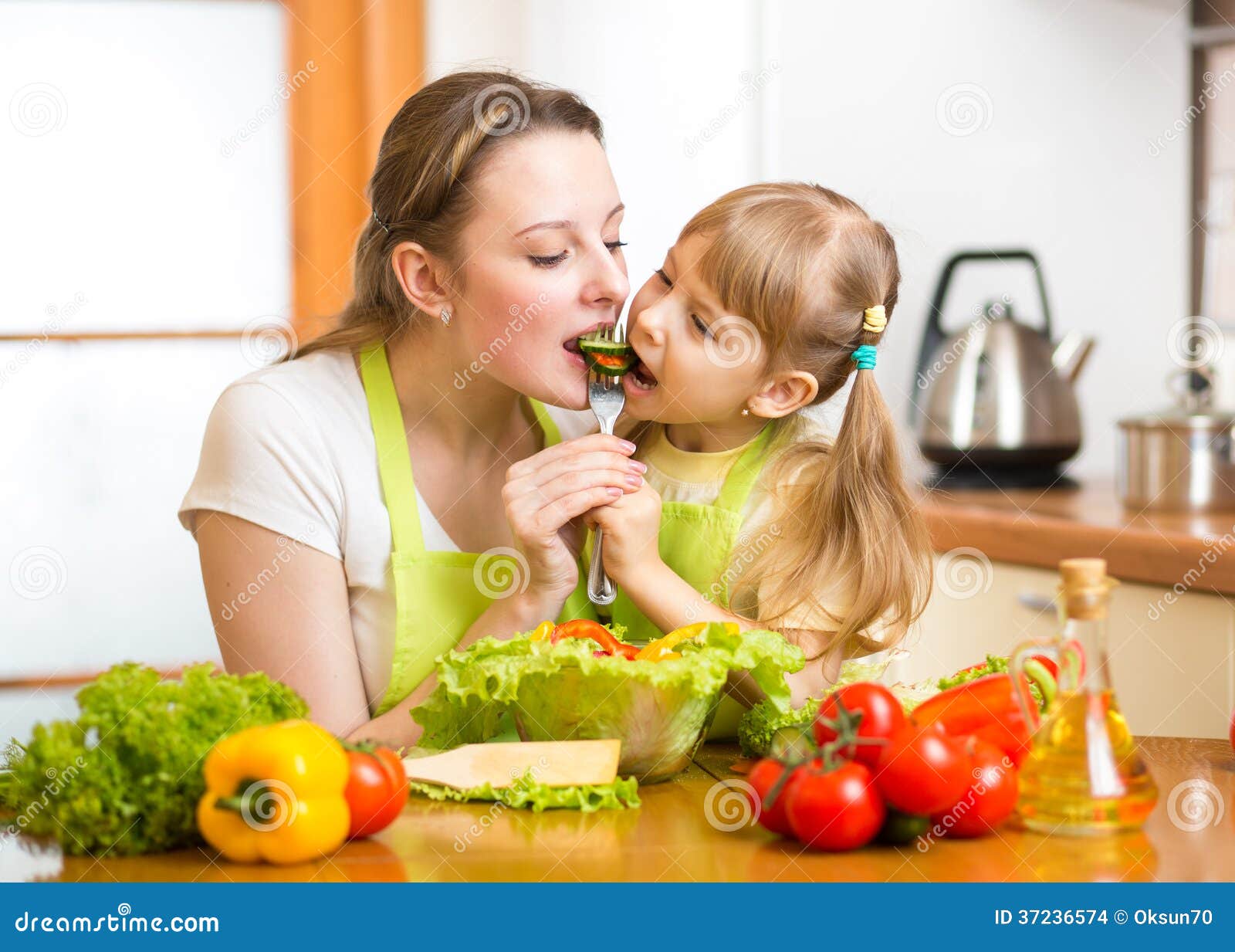 Mother and Kid Eat Vegetables in Kitchen Stock Photo - Image of family ...