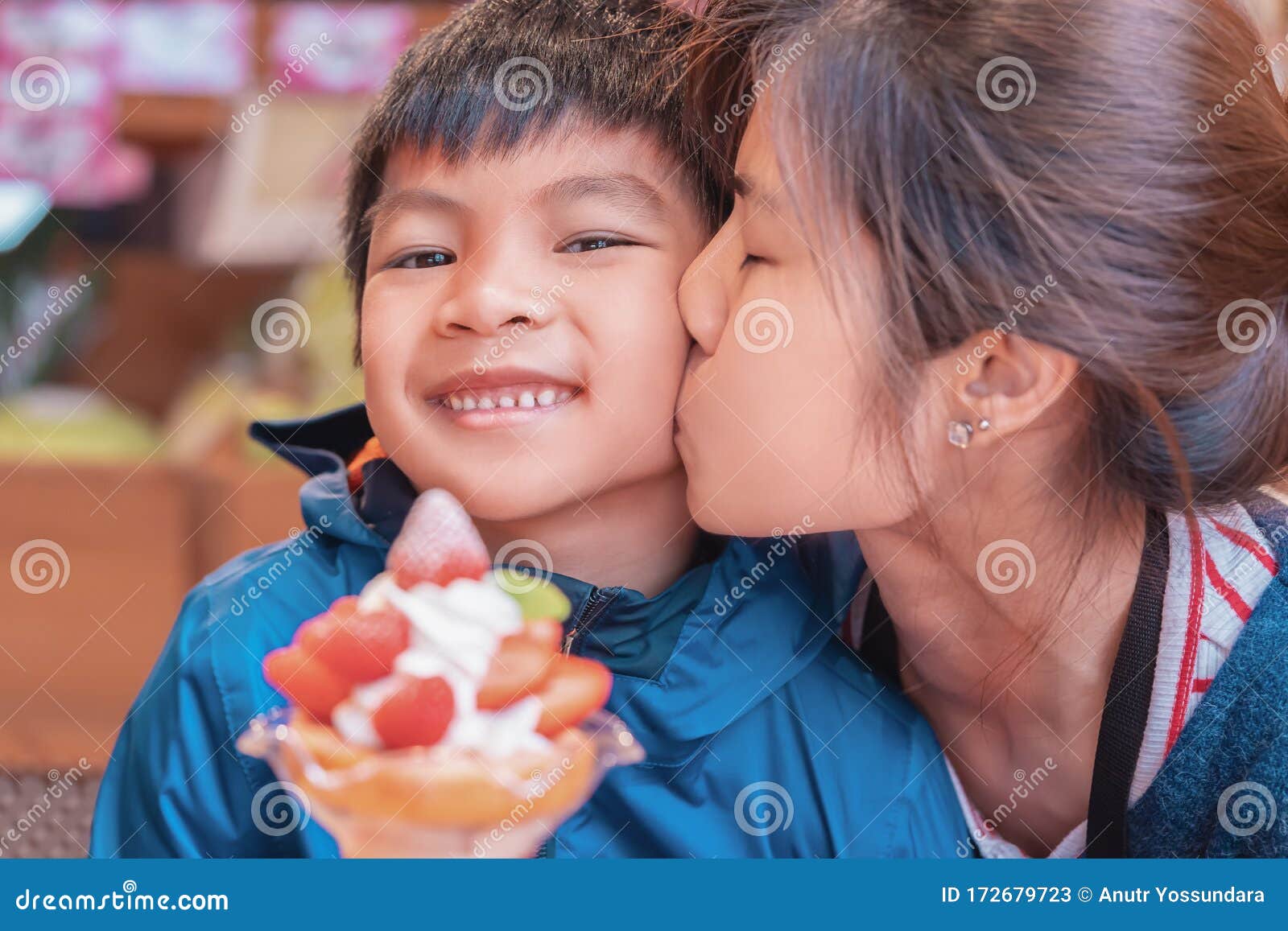 Mother Kissing Her Son Smiling While Eating Strawberry Dessert Ice