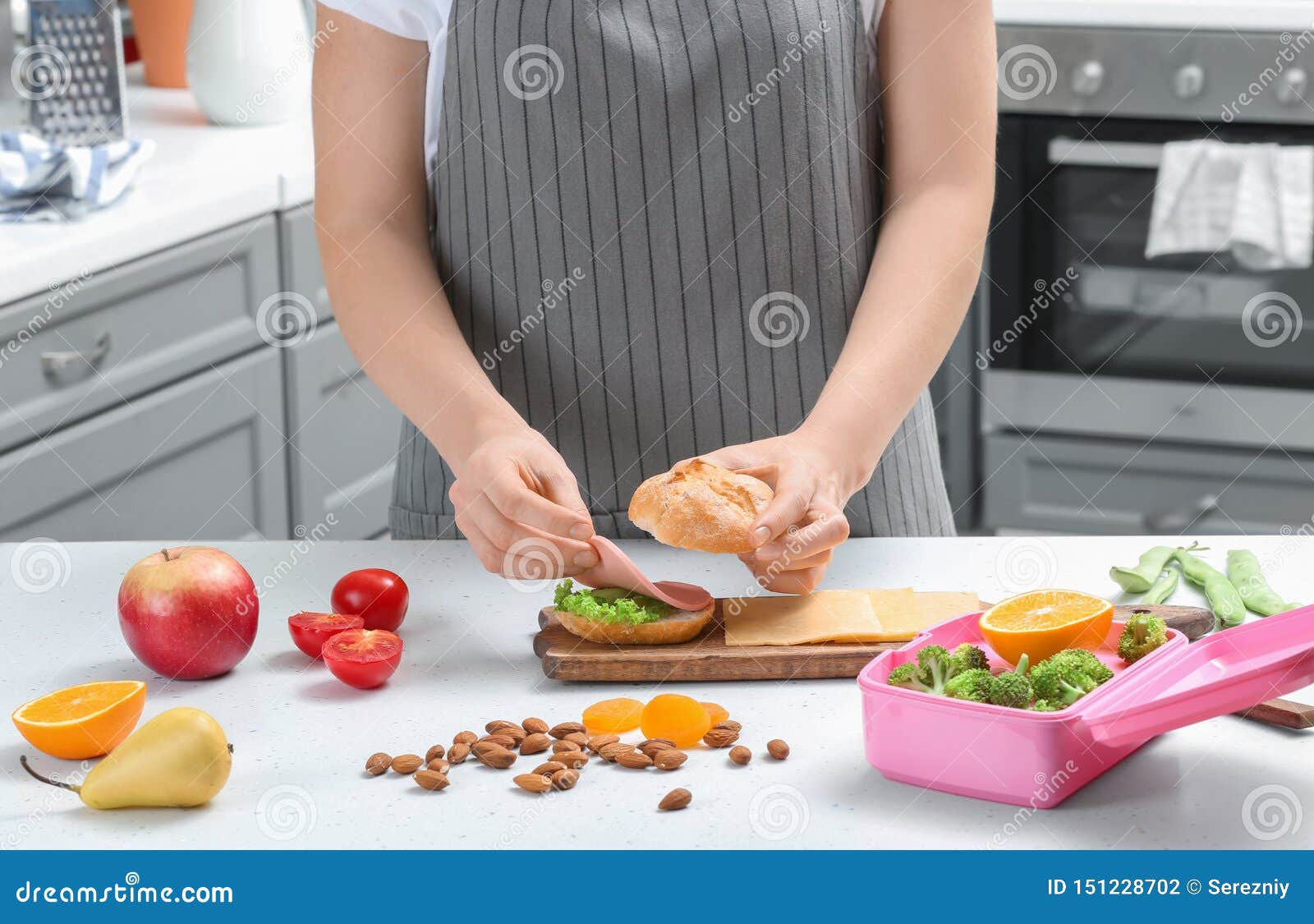 Mother Making Sandwich for School Lunch at Table in Kitchen Stock Photo ...