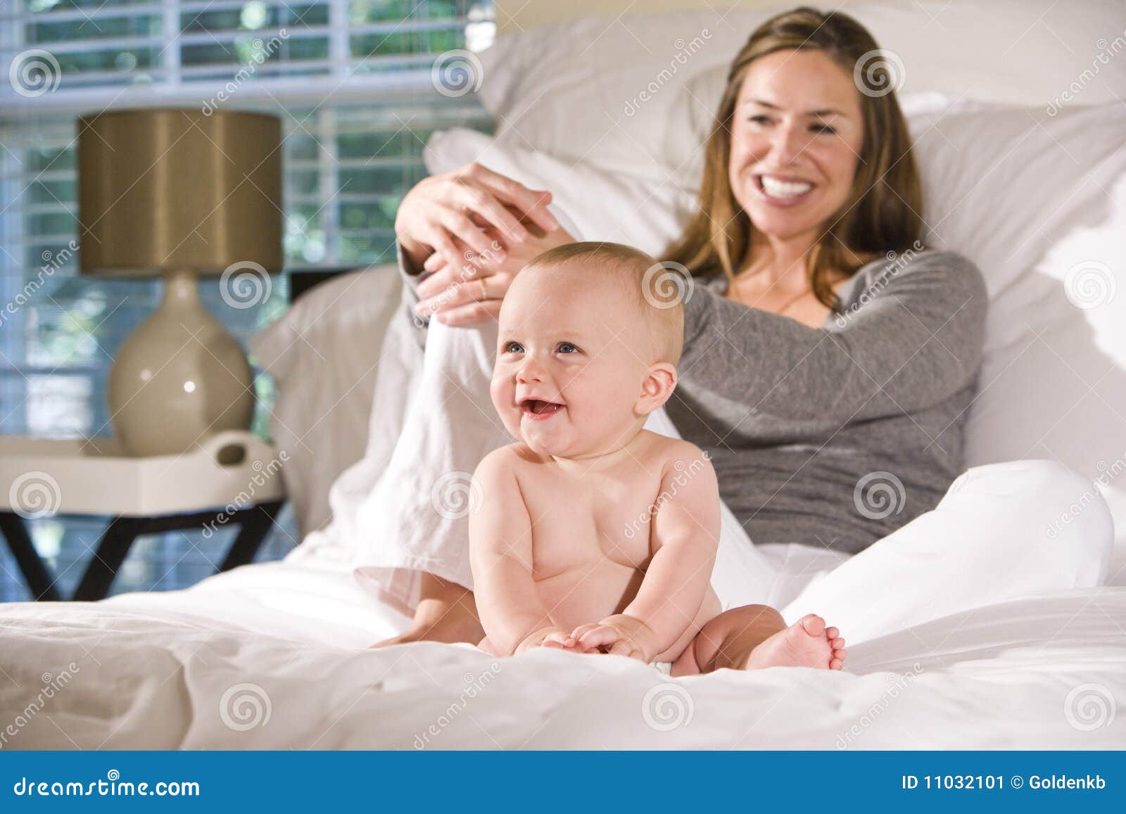 Mother Sitting on Bed with Amused Baby Stock Image - Image of child ...