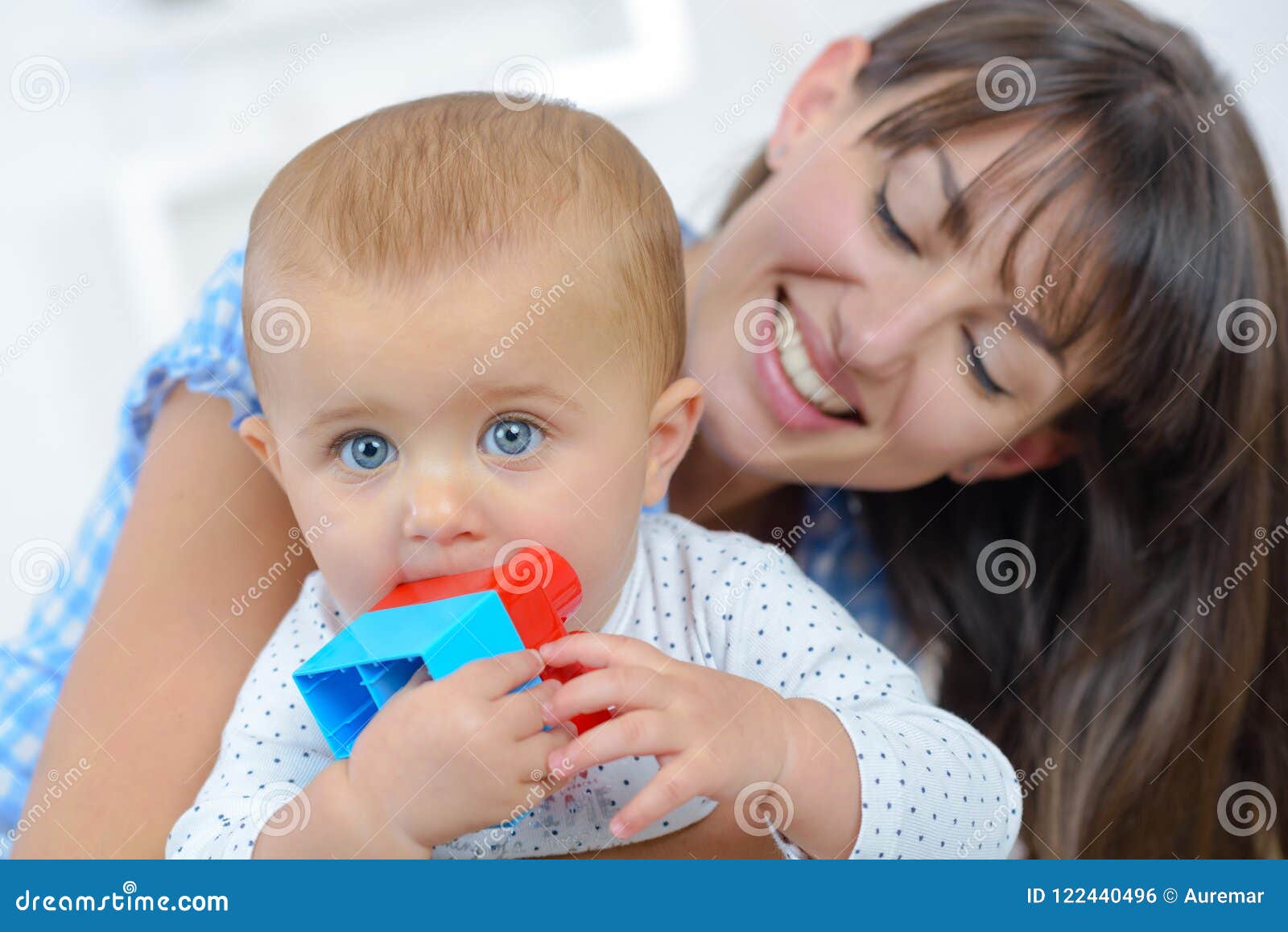 Mother Smiling at Baby Chewing Toy Stock Photo - Image of mother, chew ...