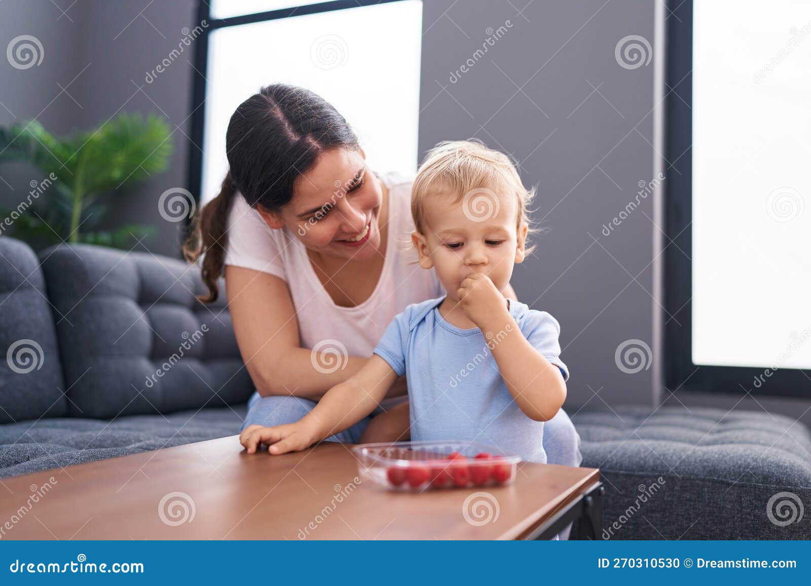 Mother and Son Smiling Confident Eating Raspberries at Home Stock Photo ...