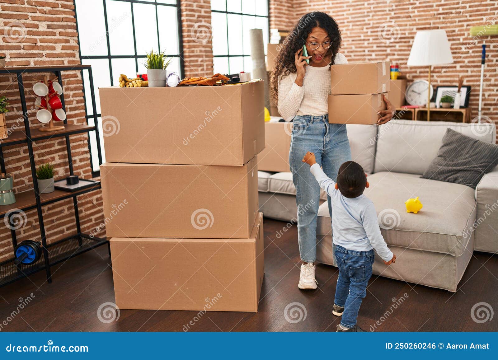 Mother and Son Talking on the Smartphone Holding Package at New Home ...