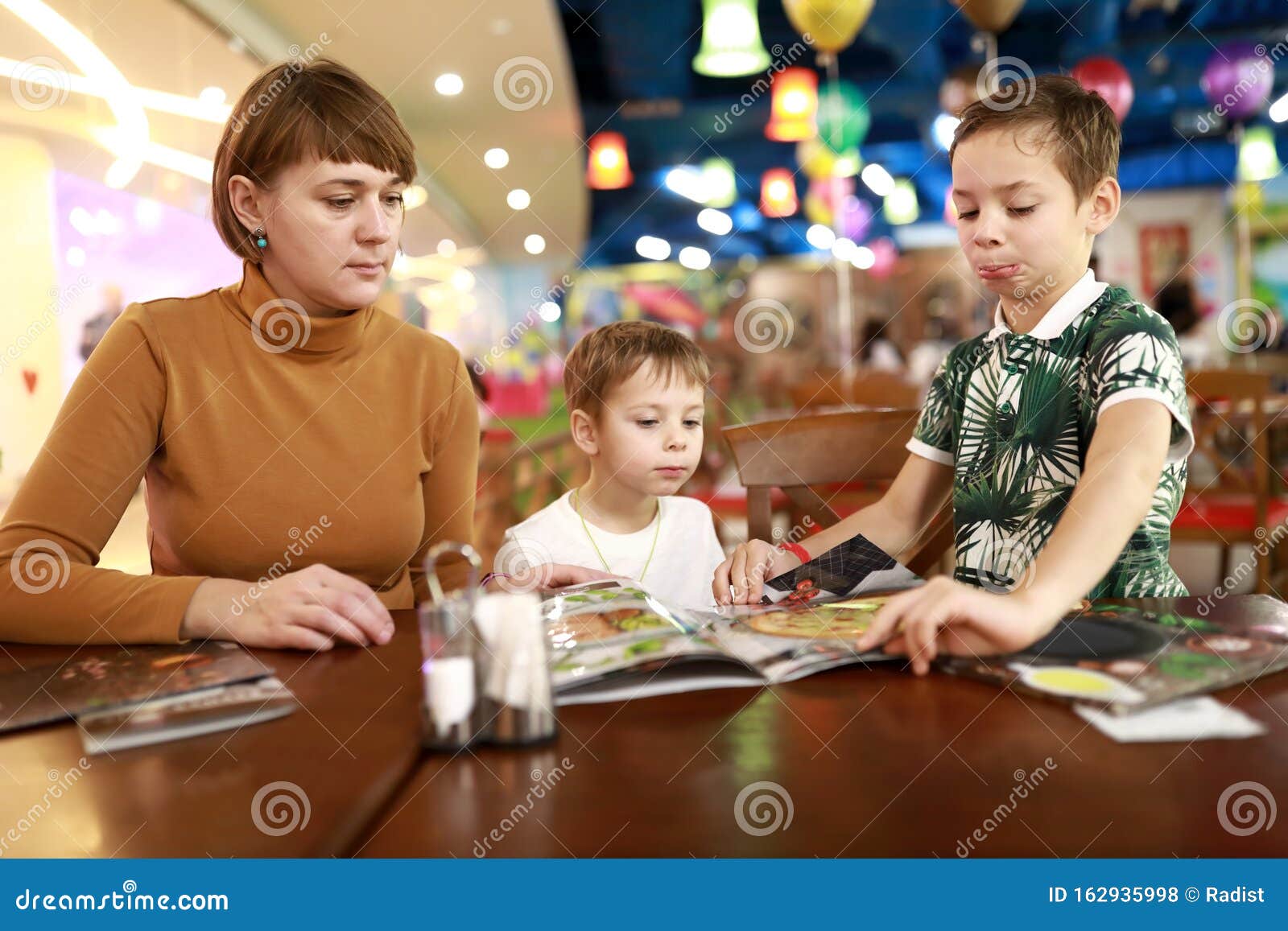 Mother with Sons Choosing Dish in Menu Stock Photo - Image of lifestyle ...