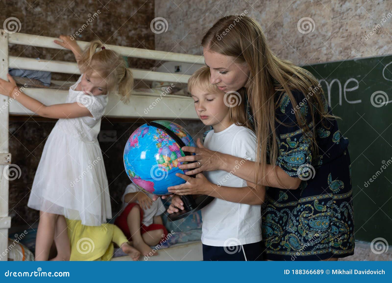 Mother is Studying a World Map on a Globe with Her Children. Stock ...