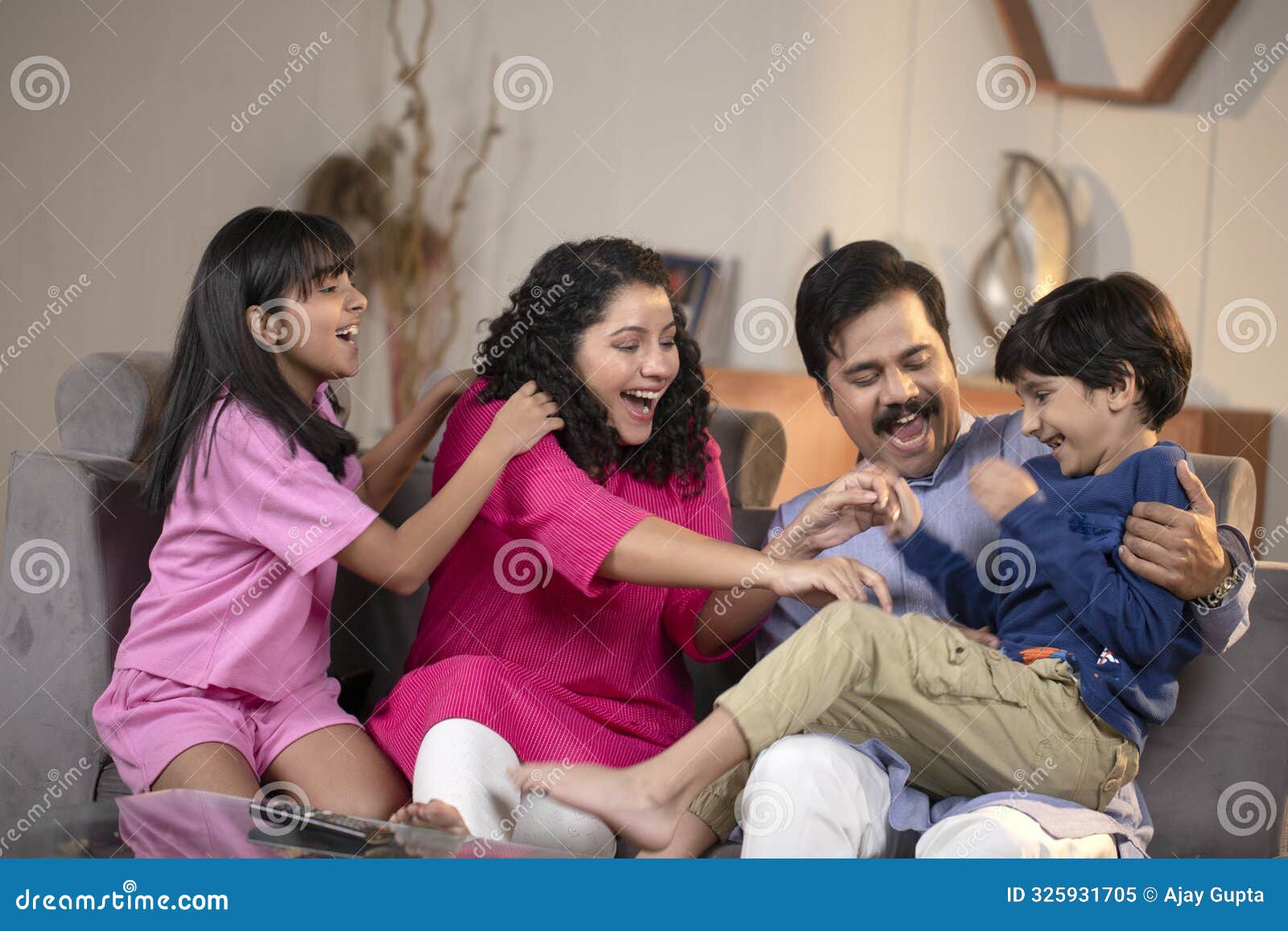 Mother Tickling Her Son Sitting On Father Lap Stock Image Image Of
