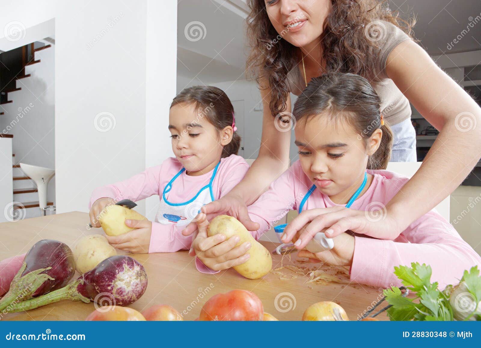 Mother and Twins Peeling Potatoes in Kitchen Stock Photo - Image of ...