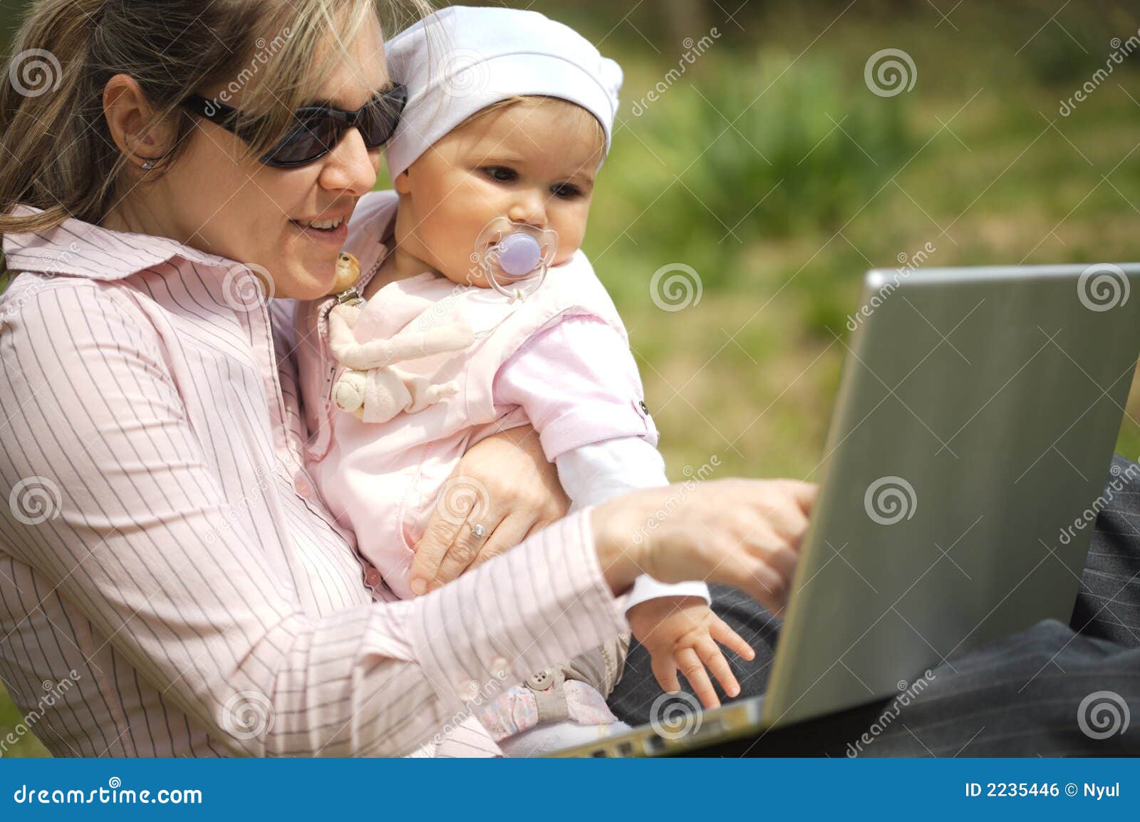 Mother uses a laptop stock photo. Image of mother, care - 2235446