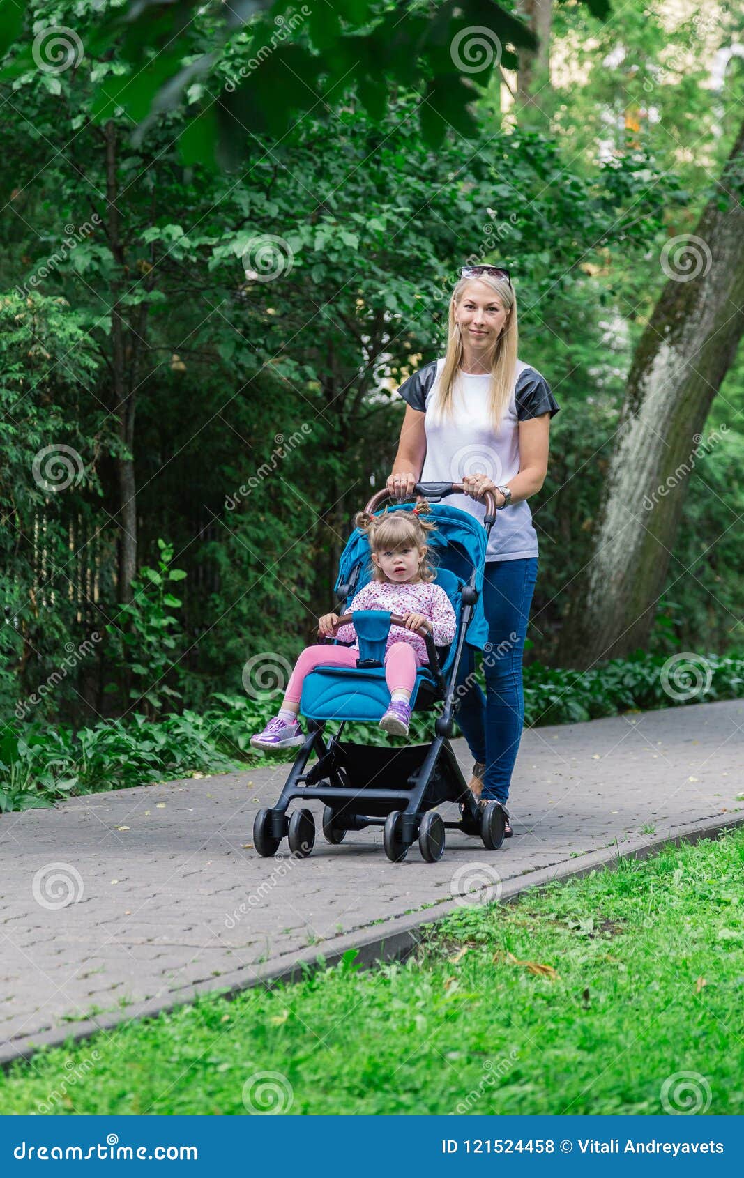 Mother Walking while Pushing a Stroller in the Park Stock Photo - Image ...