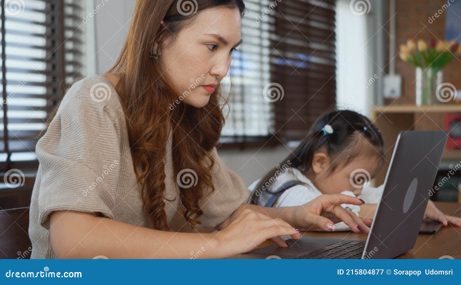 Mother Working with Laptop Computer at Home and Help Daughter Doing ...