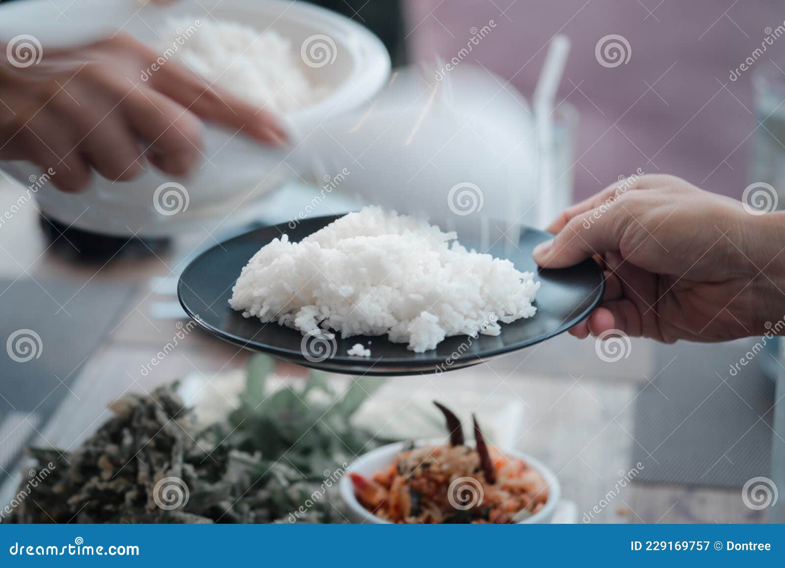 Motion Blur Hand and is Scooping Jasmine Rice Cooking into a Dish Stock ...