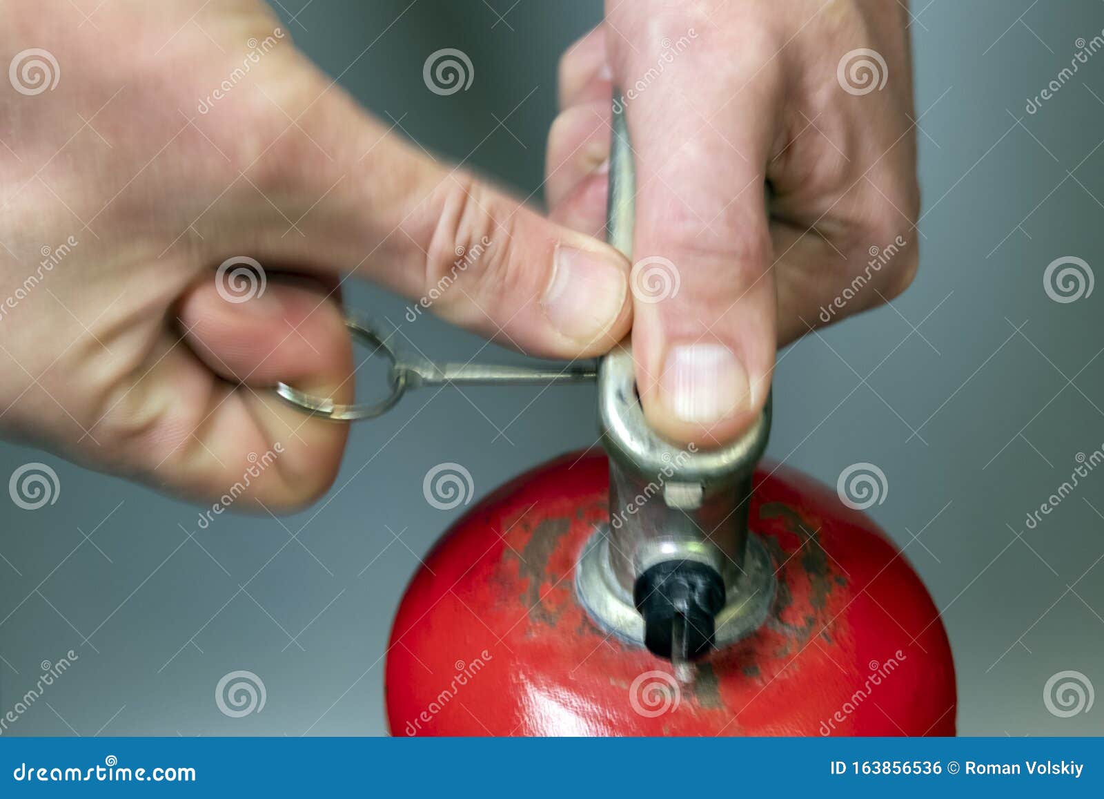 Motion Blur. a Man Pulls Out a Protective Pin from a Fire Extinguisher ...