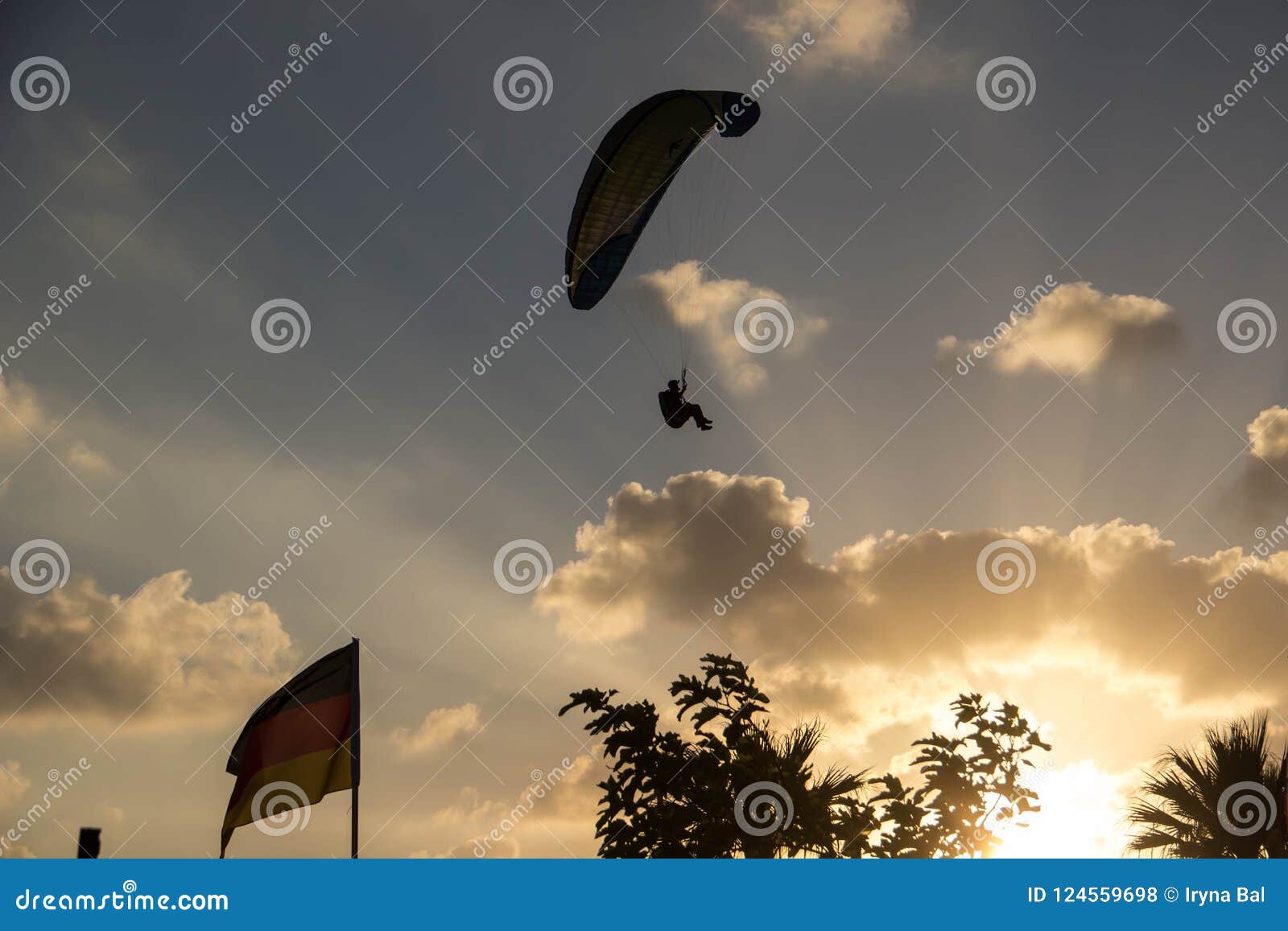 Motor Paraplan Flies in the Sky between the Clouds in the Setting Sun ...