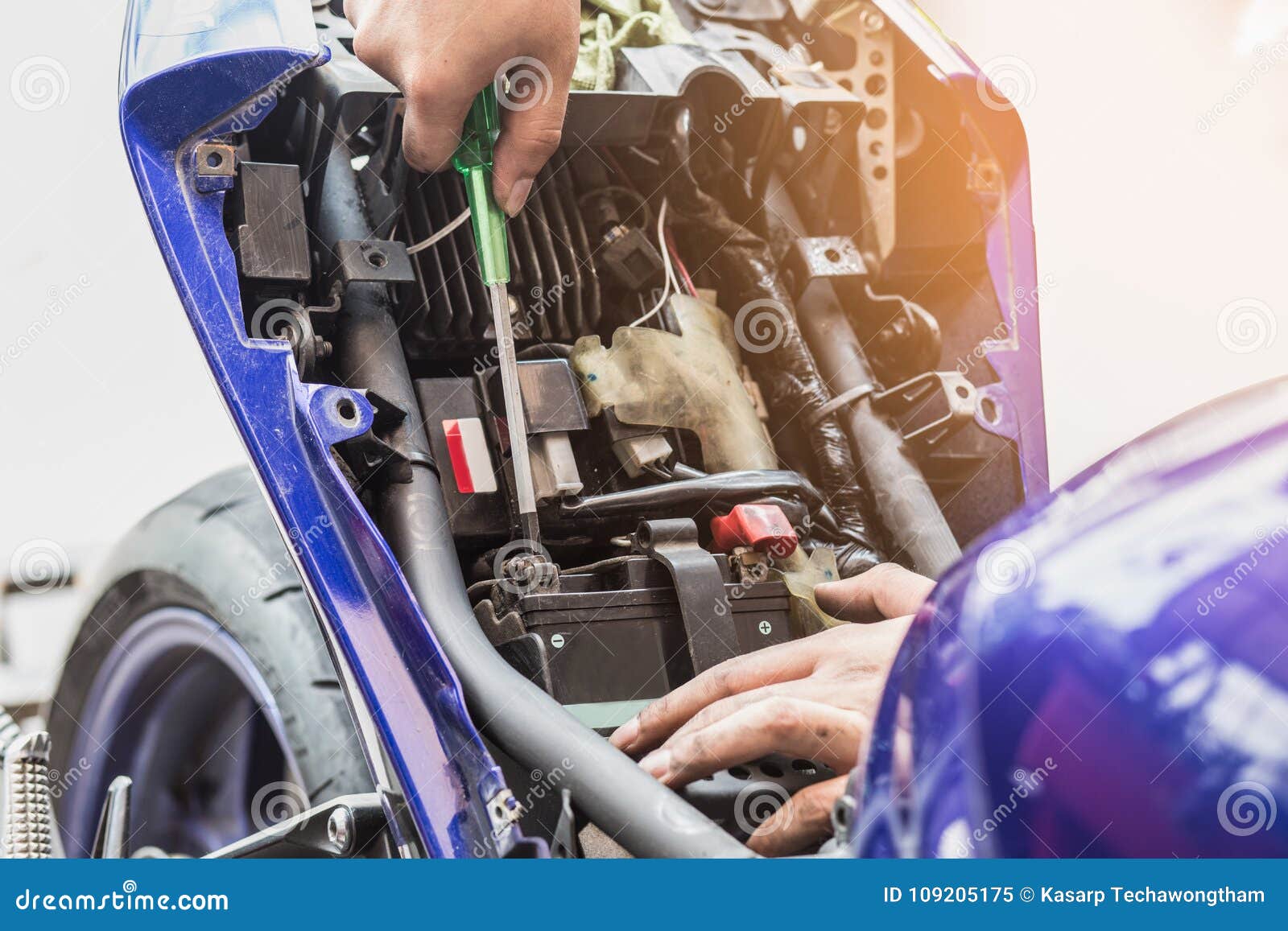 Motorcycle Mechanic Replaces a Battery. Maintenance Selective Stock ...