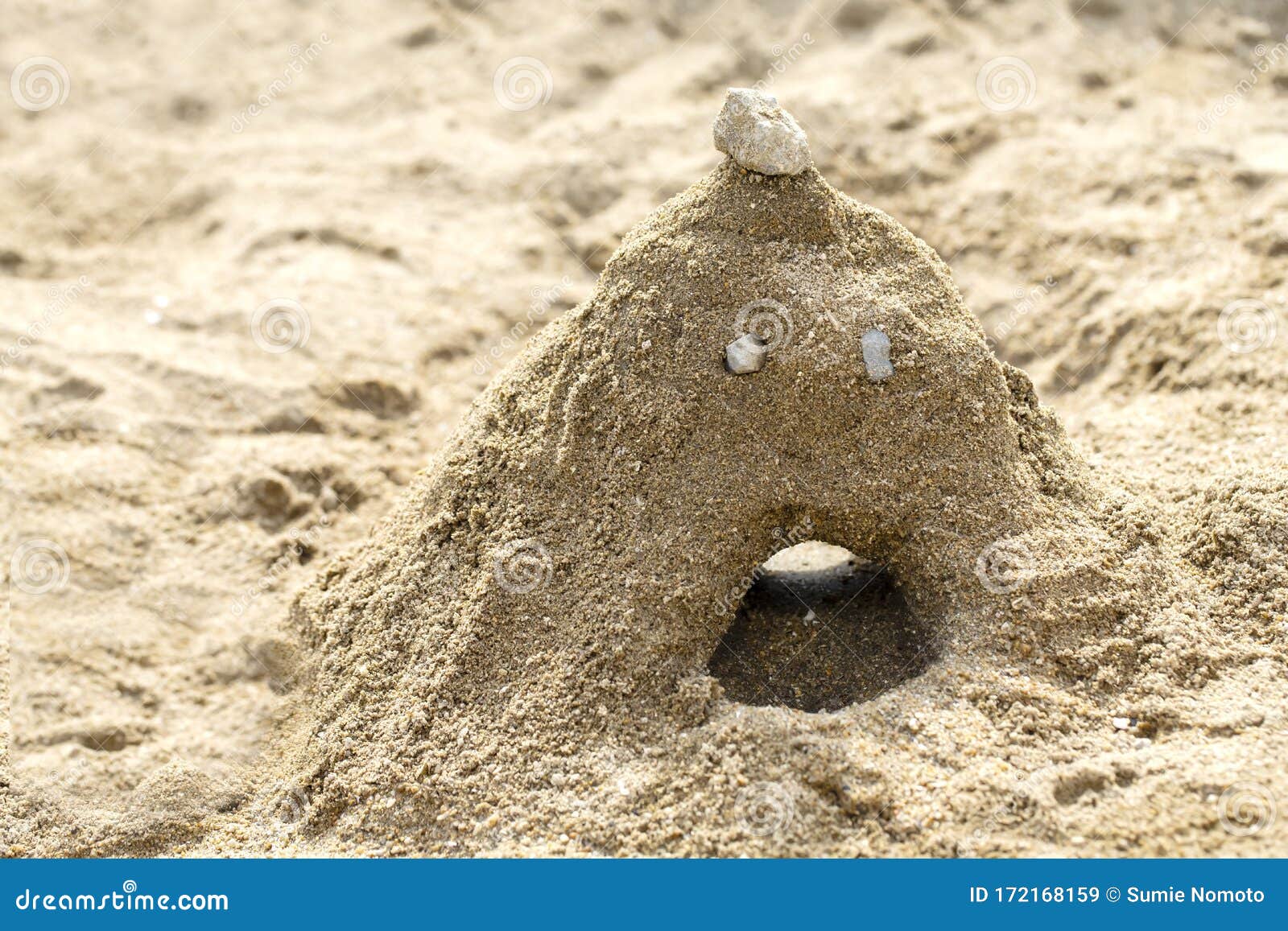 A Mountain Made of the Sand with the Face Made by Kids in Sandbox on a ...