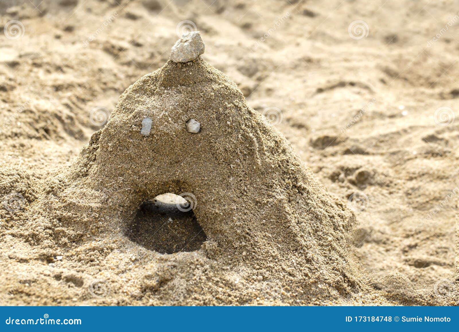 A Mountain Made of the Sand with the Face Made by Kids in Sandbox on a ...