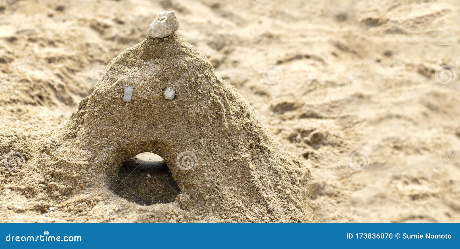A Mountain Made of the Sand with the Face Made by Kids in Sandbox on a ...