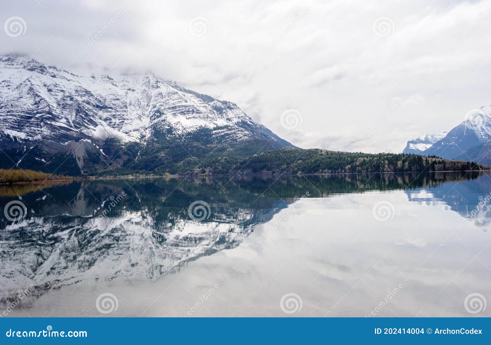 Mountain Reflection in Lake Under Overcast Sky Stock Photo - Image of ...