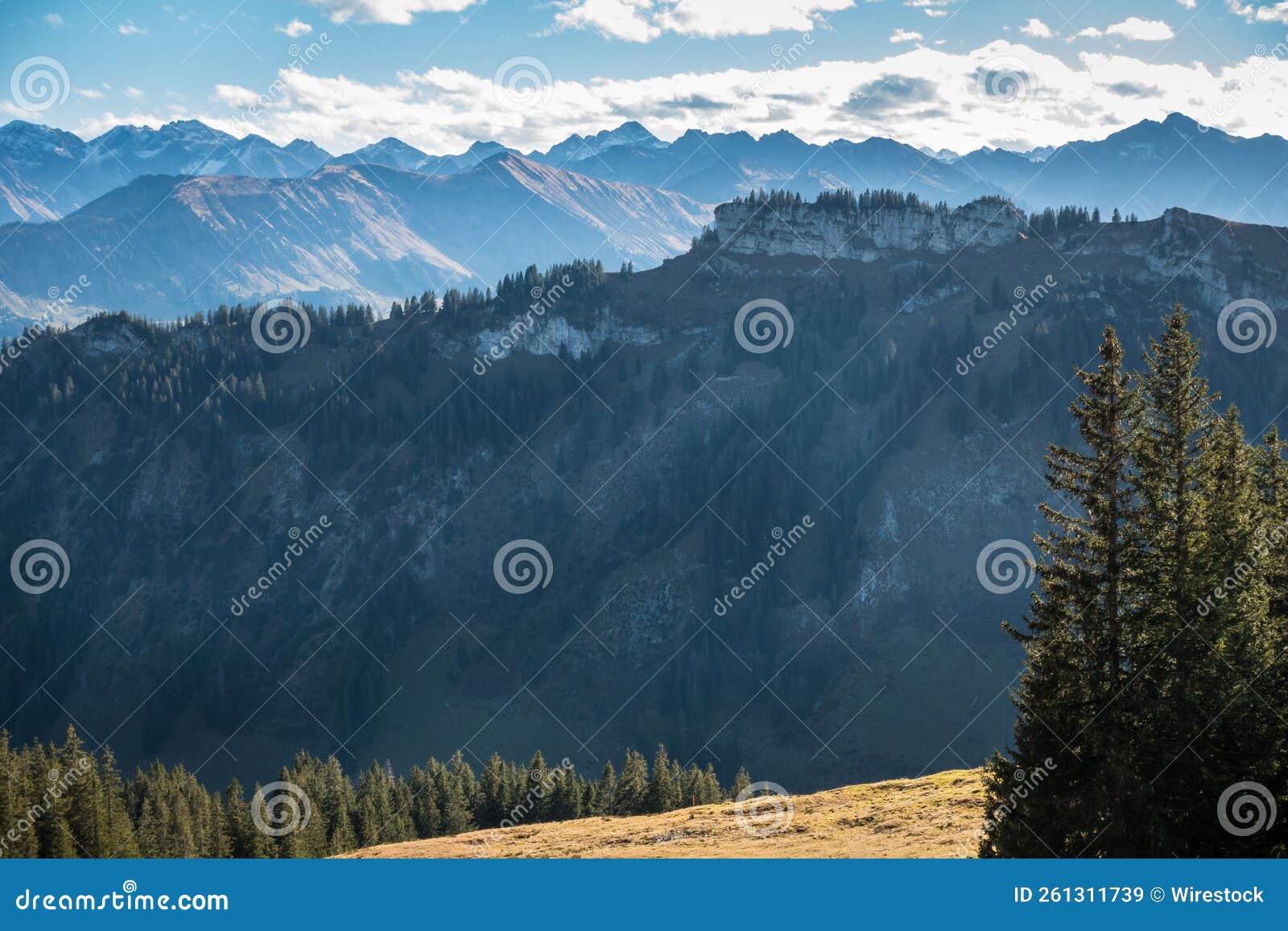 Mountain Slope in Sunlight with a Range of High Mountains in the ...