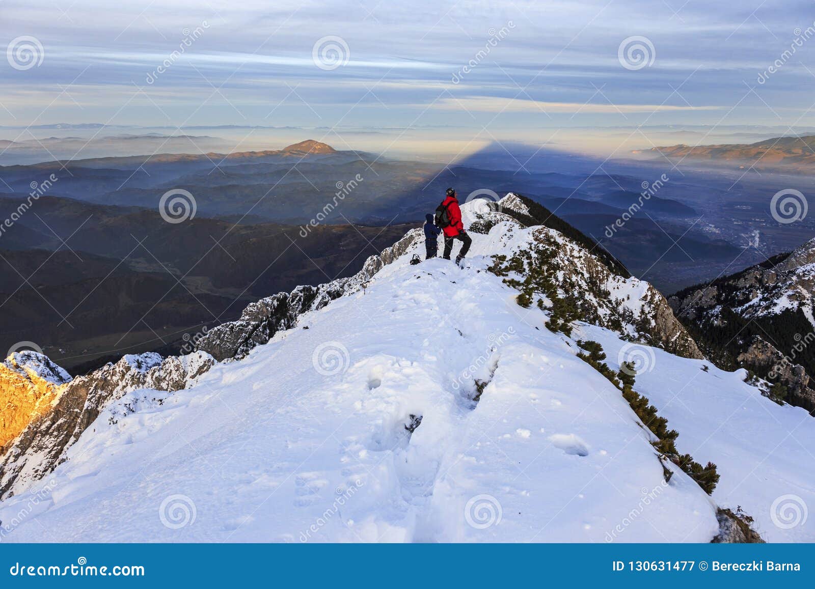Mountain Summit and Distant Hiker Watching the Sunset in Winter Stock ...