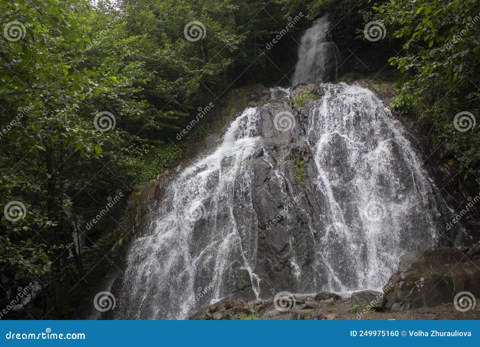 Mountain Waterfall Flows Over the Rocks. View of the Mountain Cascade ...