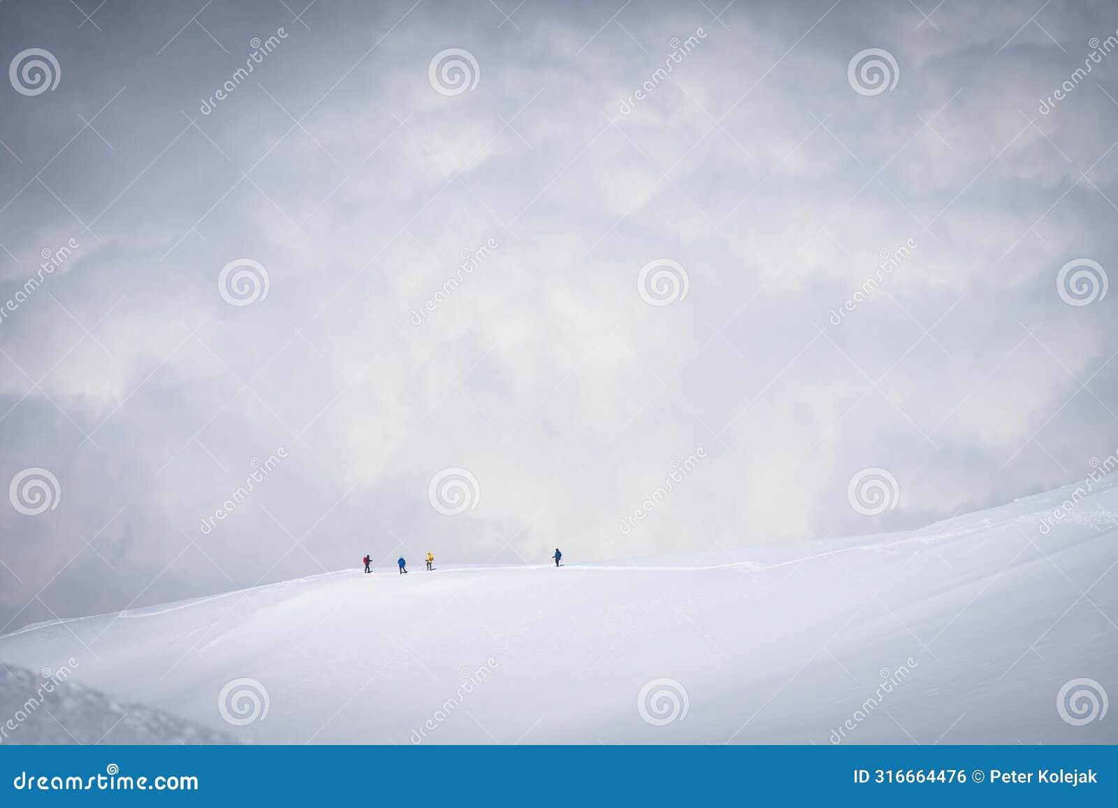 Mountaineers Going Down the Snowy Ridgeline with Clouds in Backdrop ...