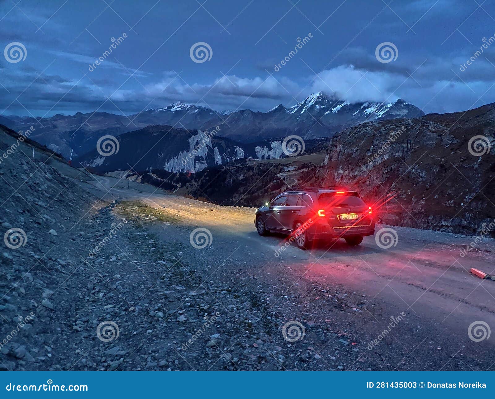 Mountains Range with Clouds and Blue Sky Road with Car at Dusk Night ...