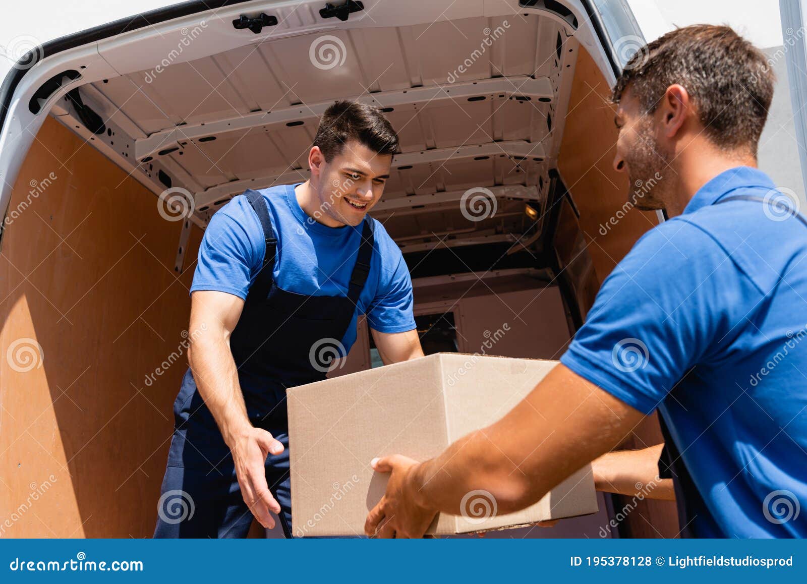 Movers with Box Unloading Truck on Stock Photo - Image of coworkers ...