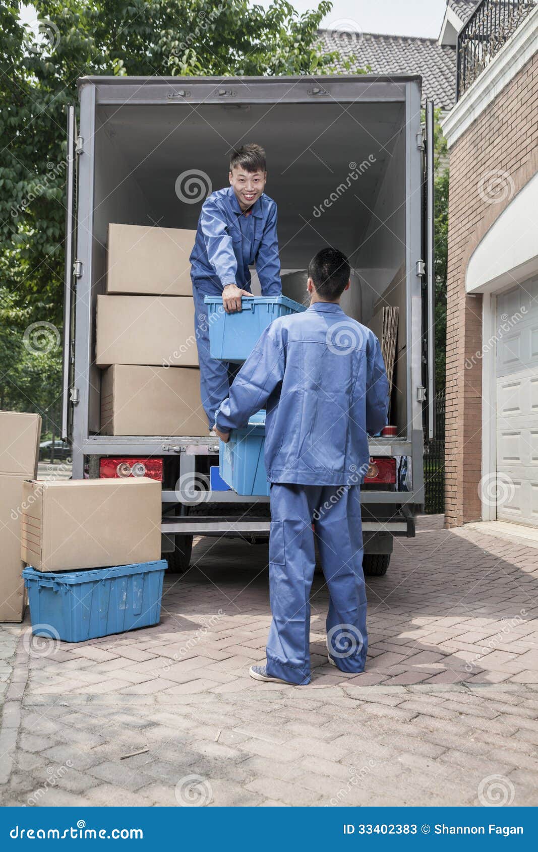 Movers Unloading a Moving Van, Passing a Cardboard Box Stock Image ...