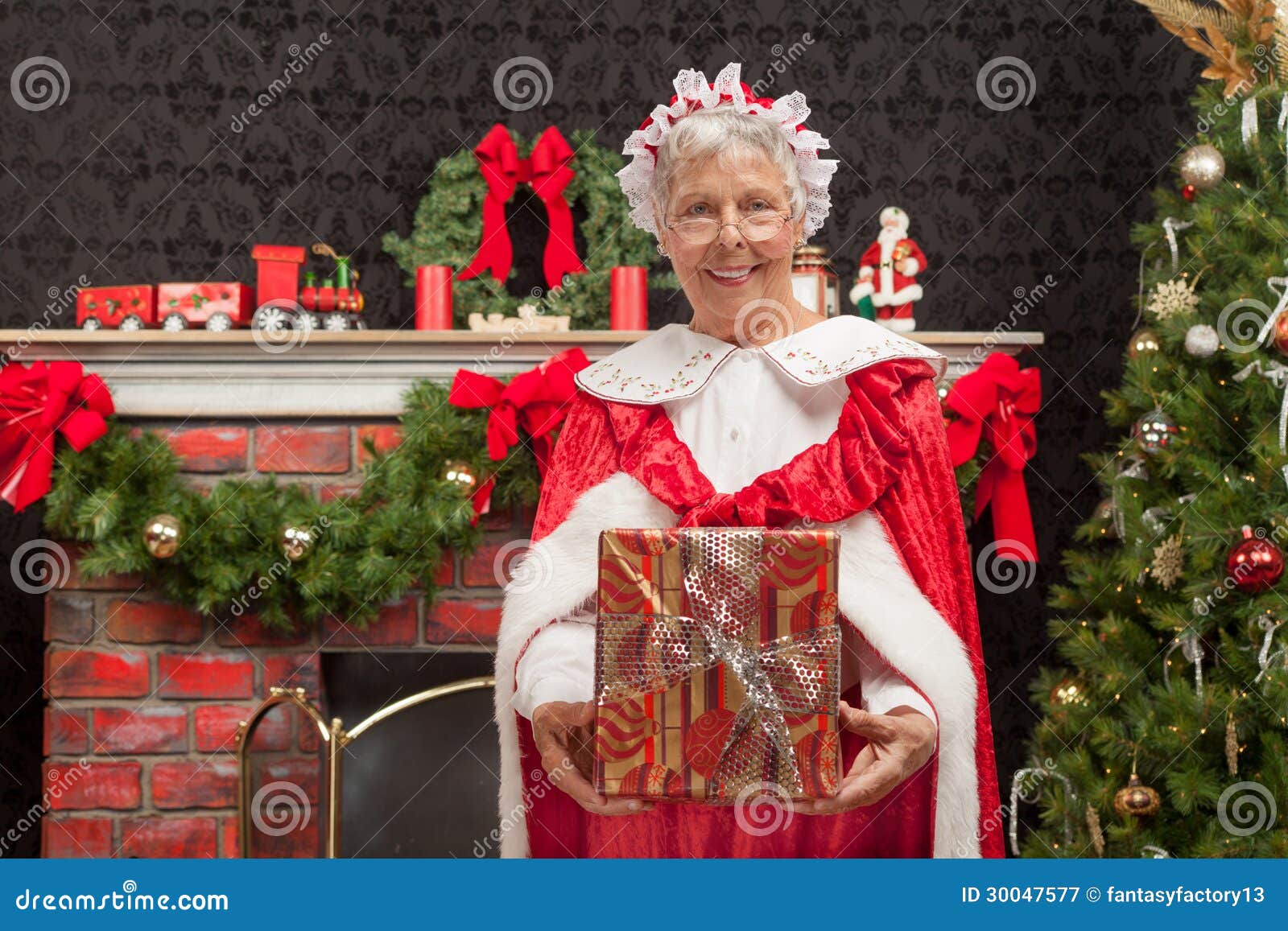 Mrs. Clause Holding a Christmas Present Stock Image - Image of clause ...